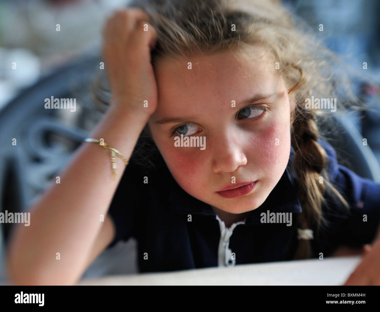 angry girl sitting at a table Stock Photo - Alamy