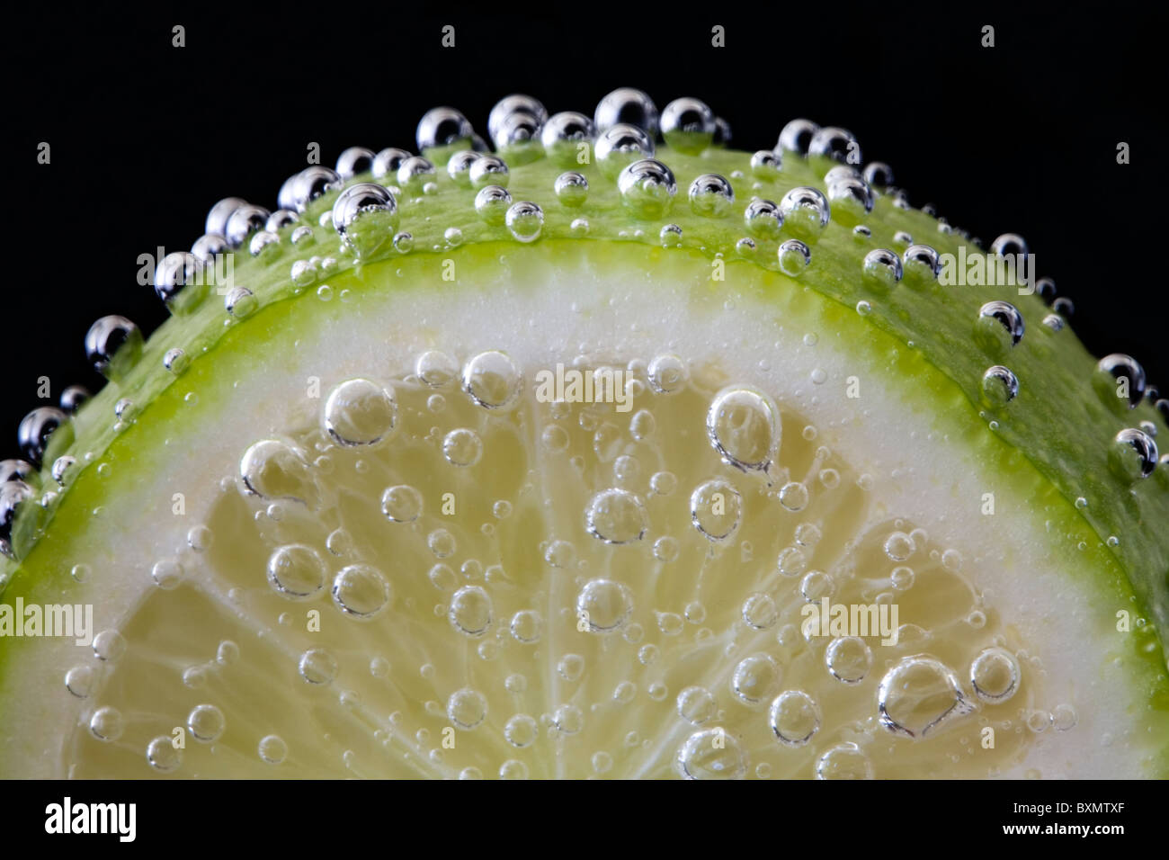 Slice of lime with bubbles Stock Photo - Alamy