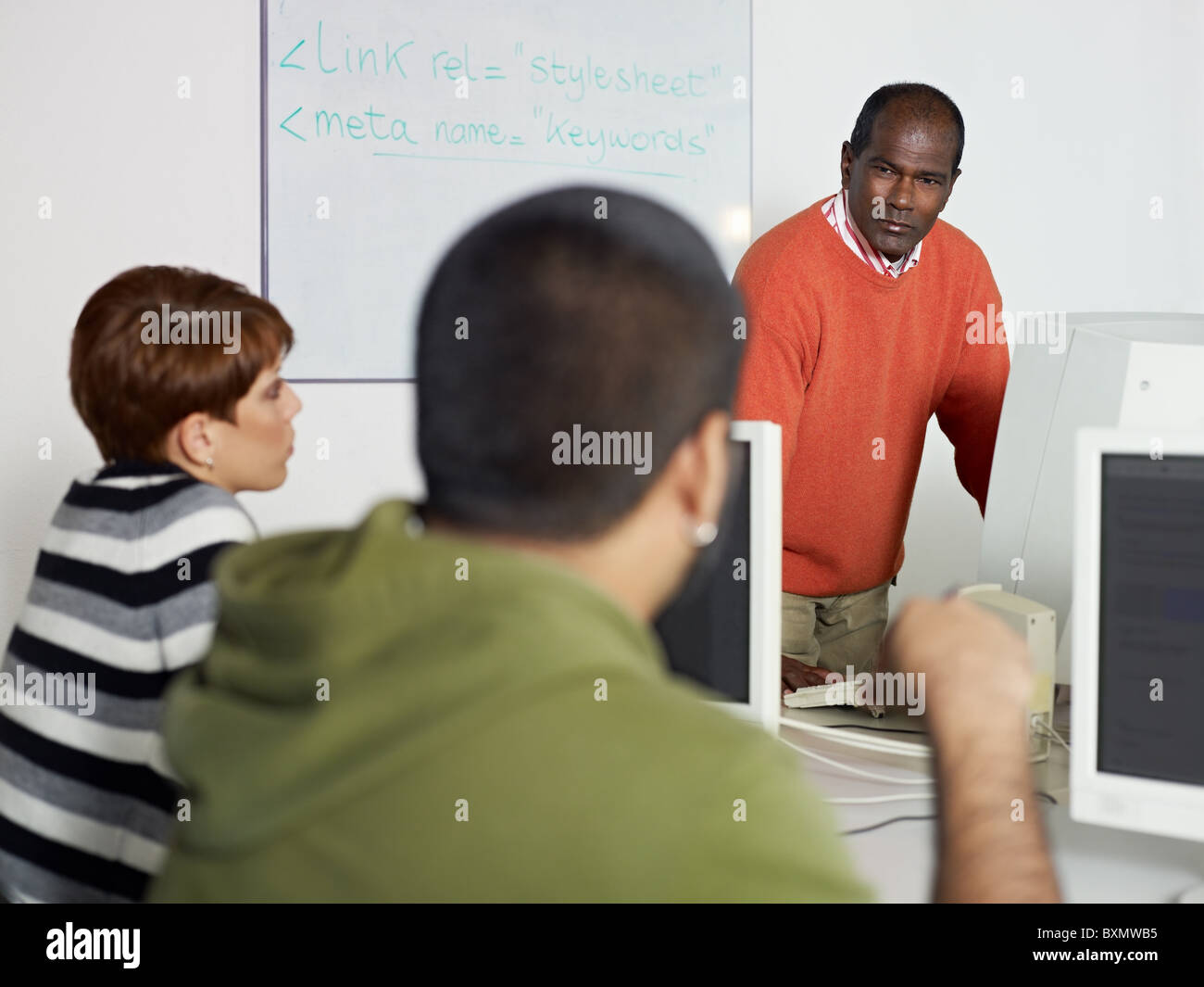 Computer class with hispanic student asking question to male indian ...