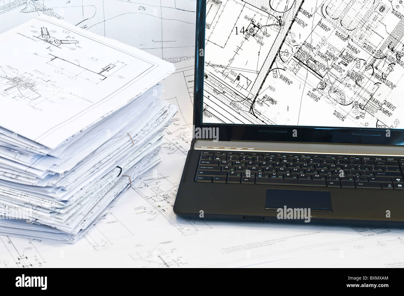 Laptop and stack of project drawings. Working place Stock Photo - Alamy