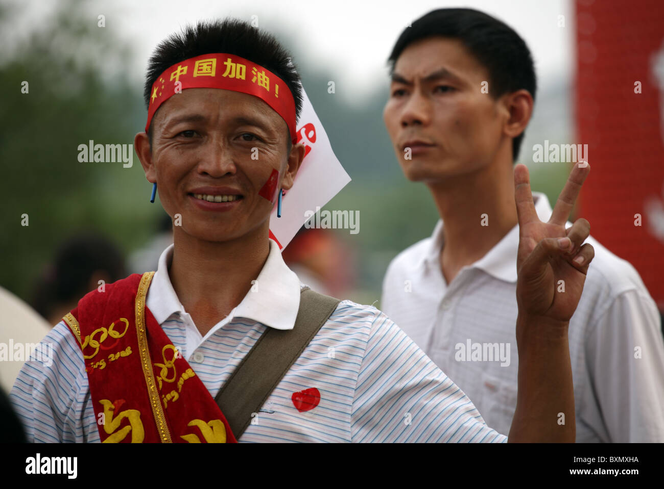 Chinese man gives peace sign during Pre-Olympic Games Parade, Beijing ...
