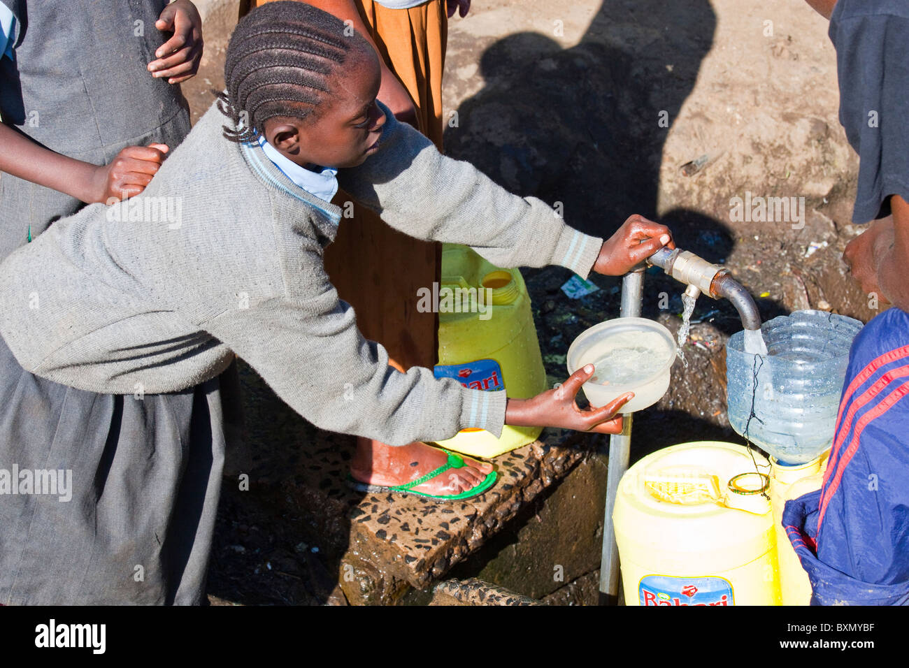 Water from a tap recently installed on the edge of Mathare slums in ...