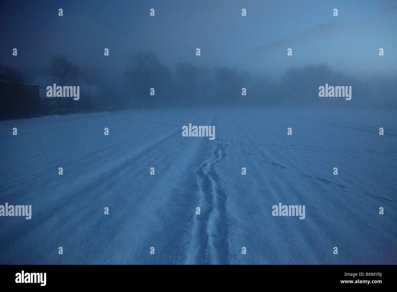 winter scene after sunset with deep snow in foreground with freezing ...