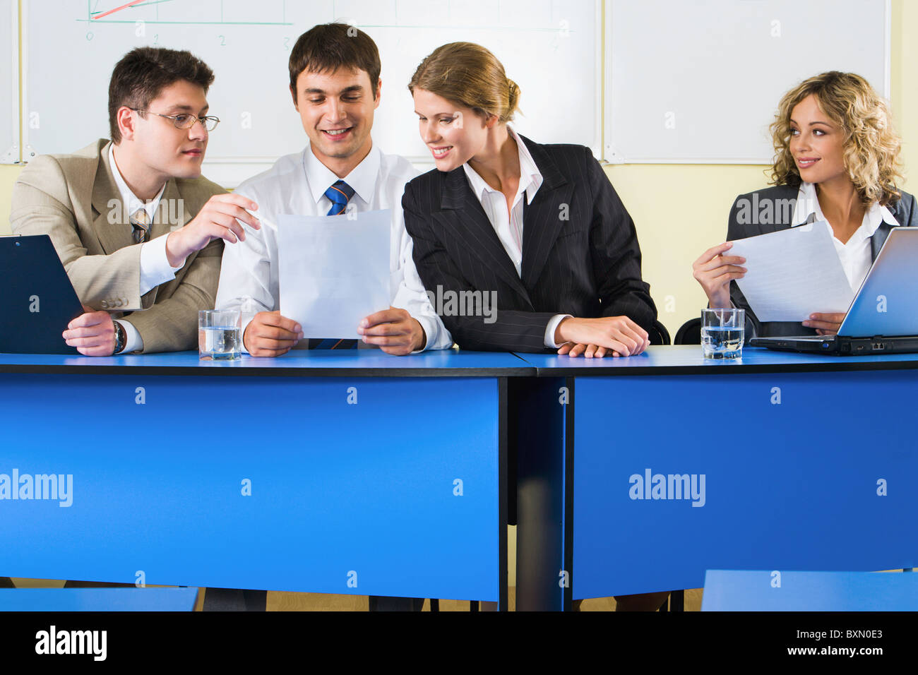 Group of people sitting at the blue table and discussing business ...