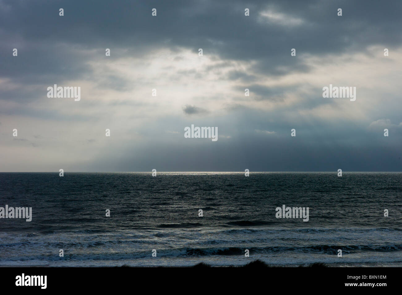 Sun's rays over rough sea at dawn on a windy day at Rosslare, South ...