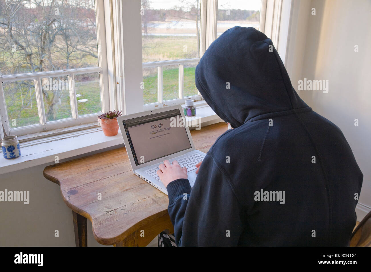 Teenage boy using google on his laptop Stock Photo - Alamy