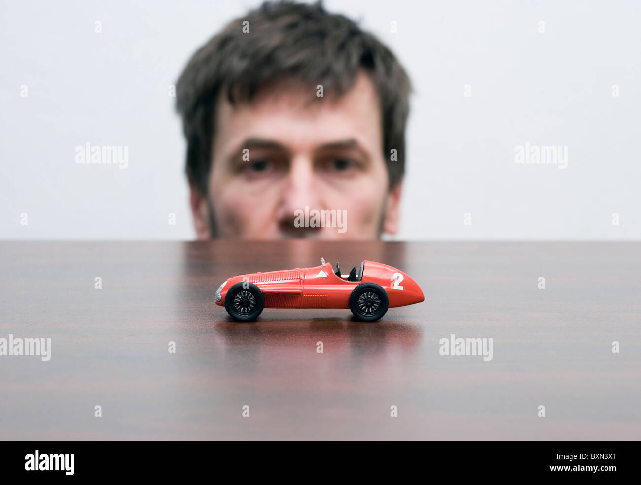 young man looking at toy car Stock Photo - Alamy