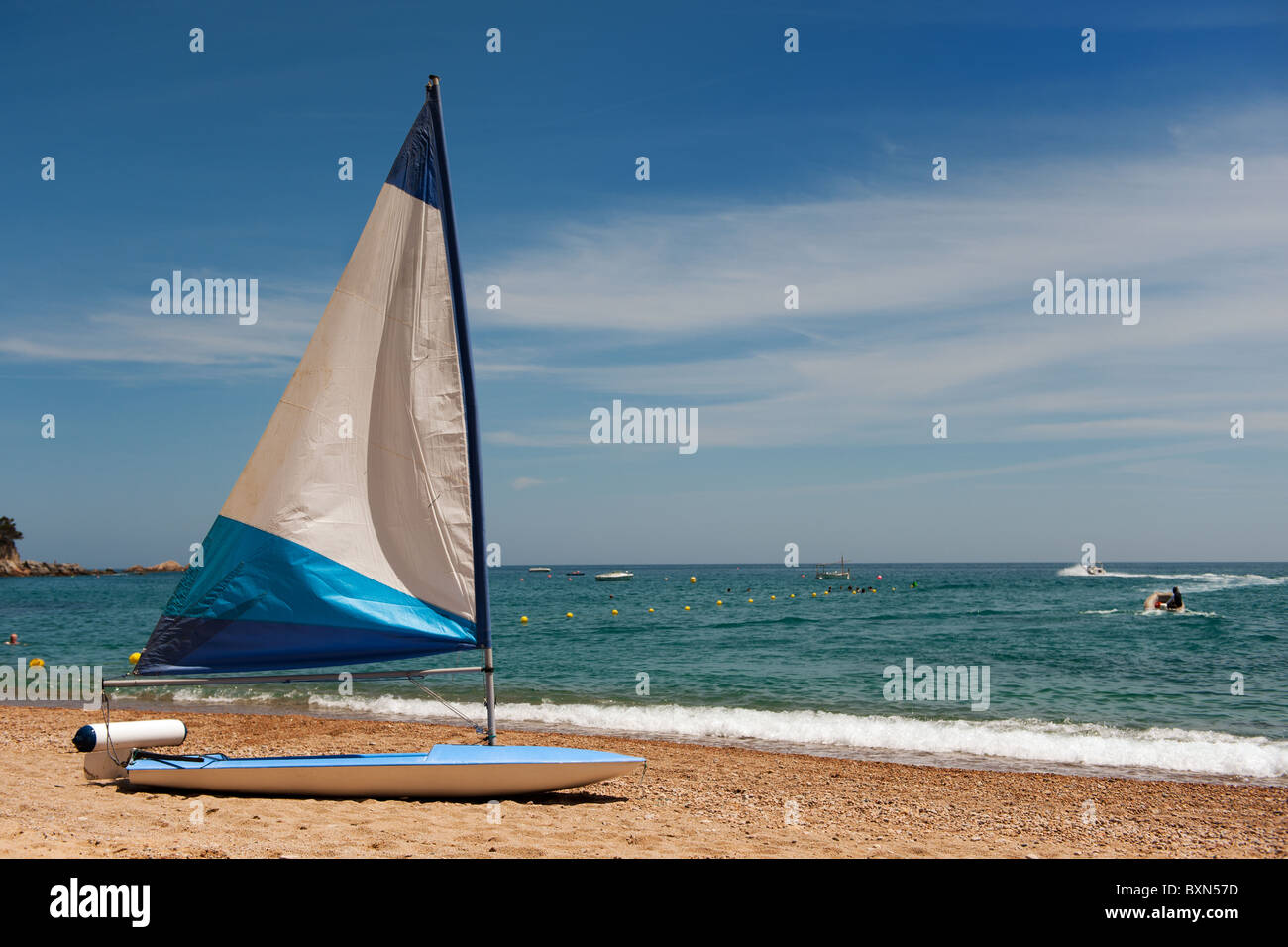 Little blue and white sail boat at the beach Stock Photo - Alamy