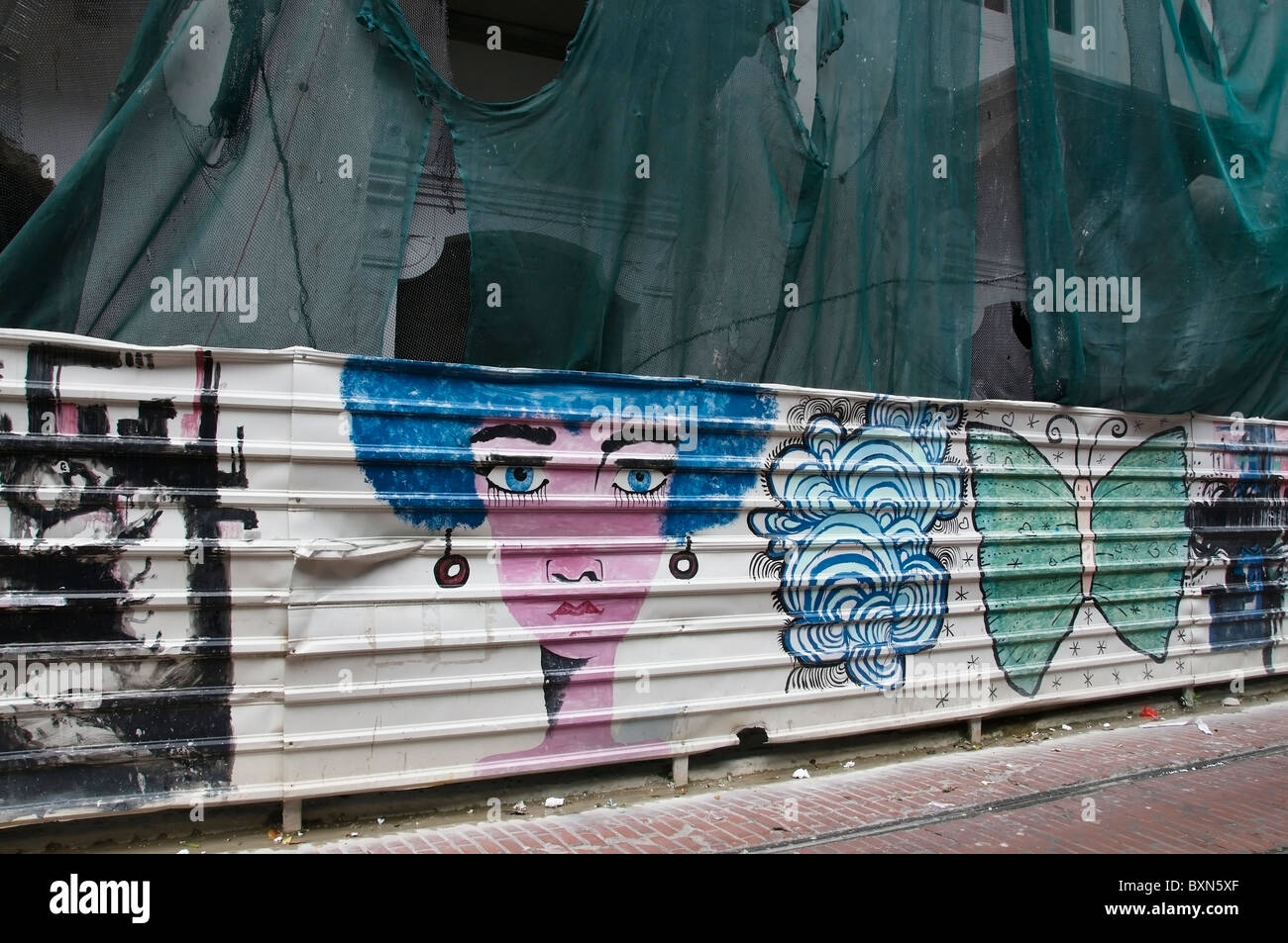 A colorful graffiti painted metal fence provides a safety barrier ...
