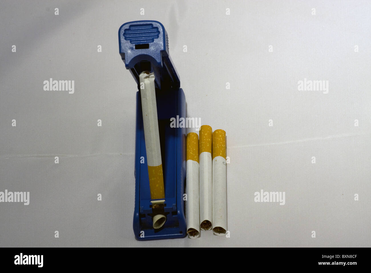 blue cigarette rolling machine filter tip tipped Stock Photo - Alamy