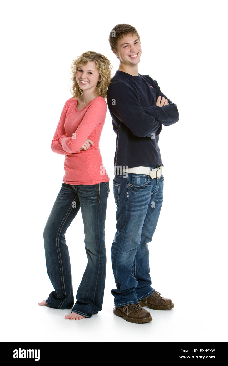 Attractive teenage couple standing back to back with arms crossed ...