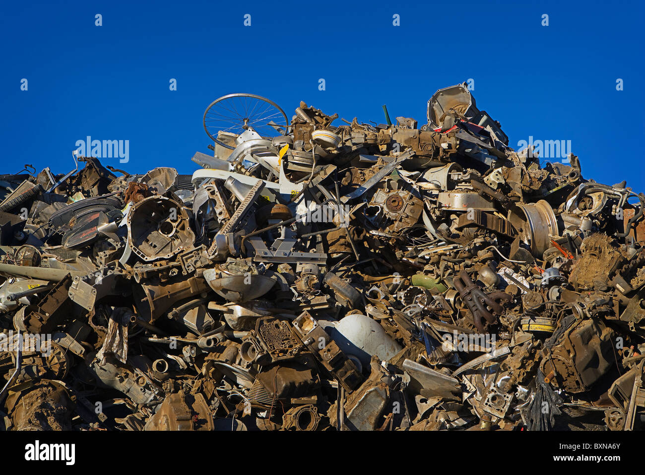 Sorted mountain of scrap metal under a clear blue sky ready for ...