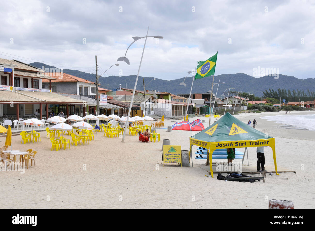 Restaurant tables and surf lesson booth on beach, Barra da Lagoa ...