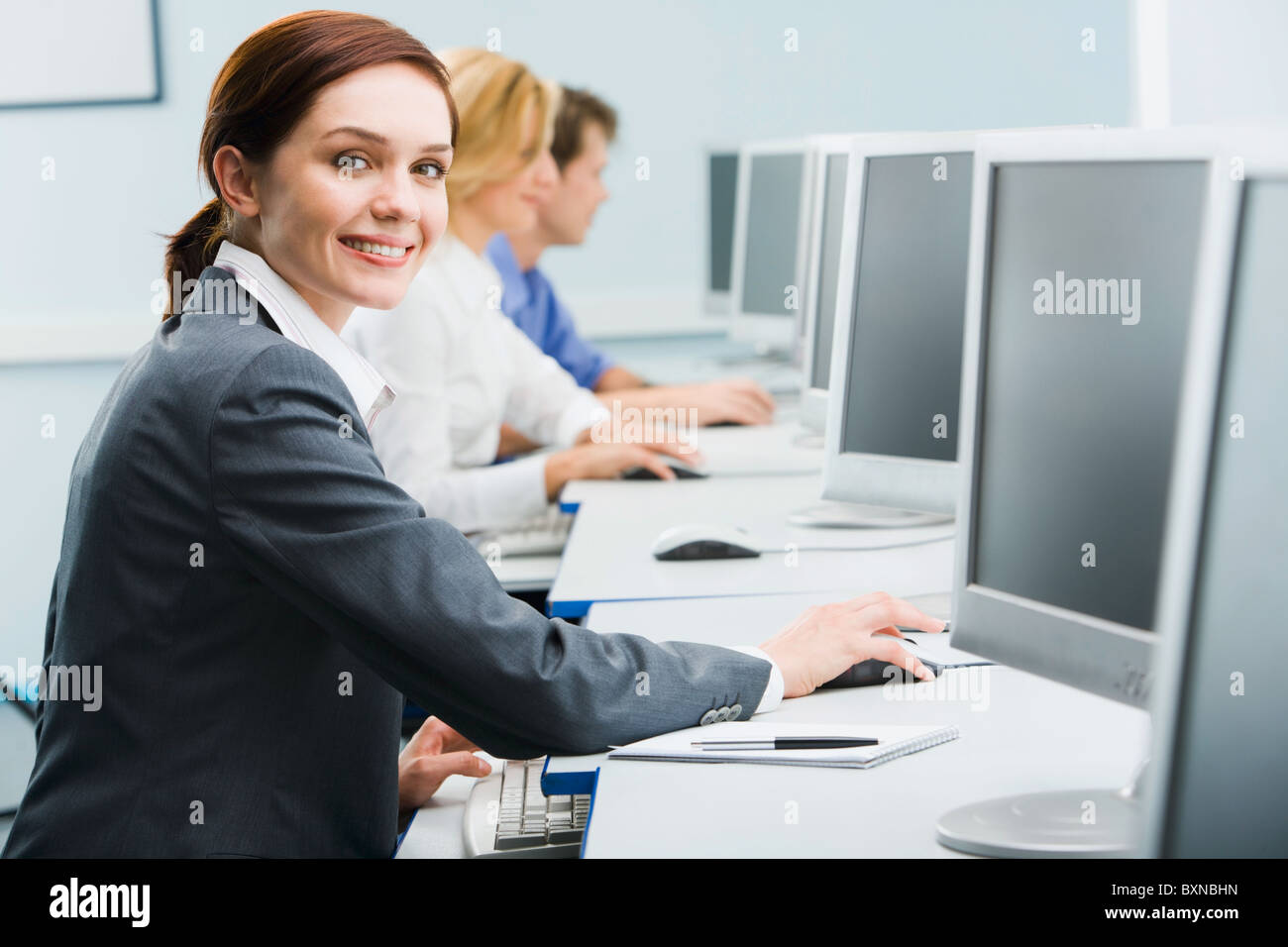 Portrait of busy woman sitting at the computer table and touching ...