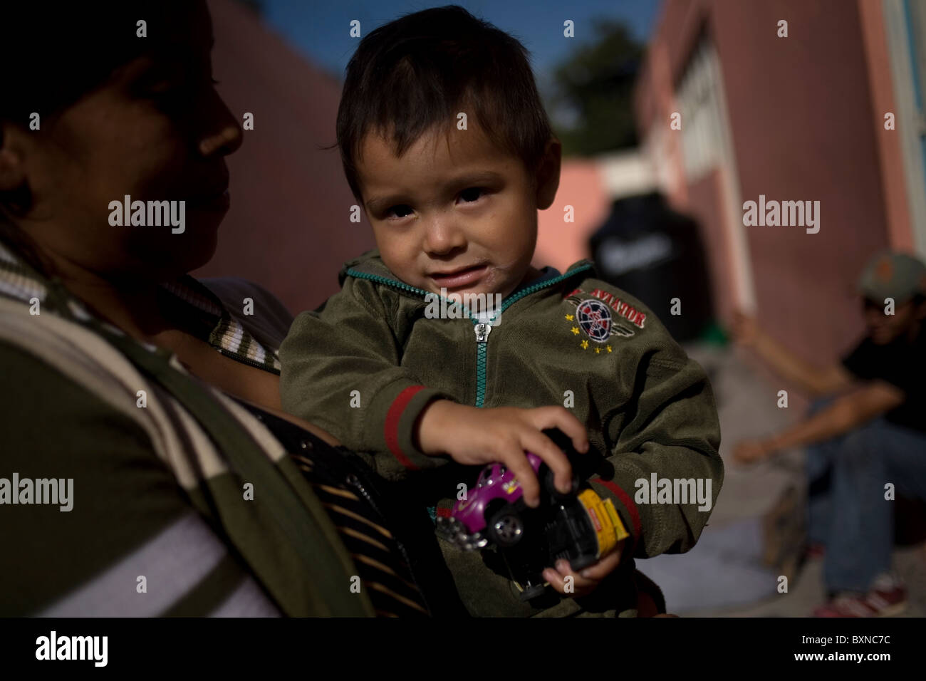 An Central American migrant woman holds her son in her arms in a ...