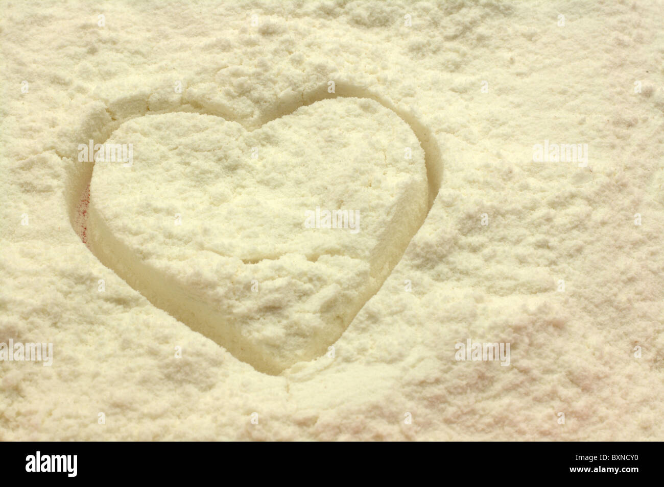 Heart shape pressed into flour Stock Photo - Alamy