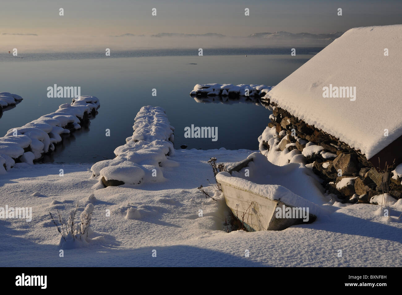 Landscape by the sea in winter, Boat, boat house and a pier of stone ...
