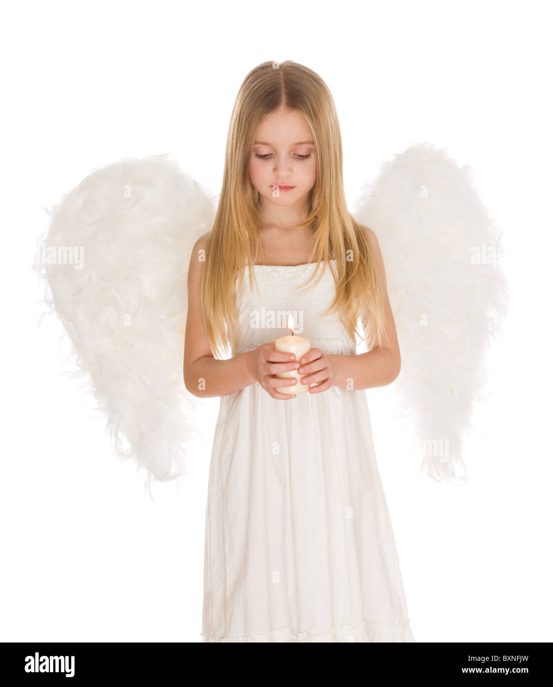 Portrait of white angel holding burning candle and looking at it over ...