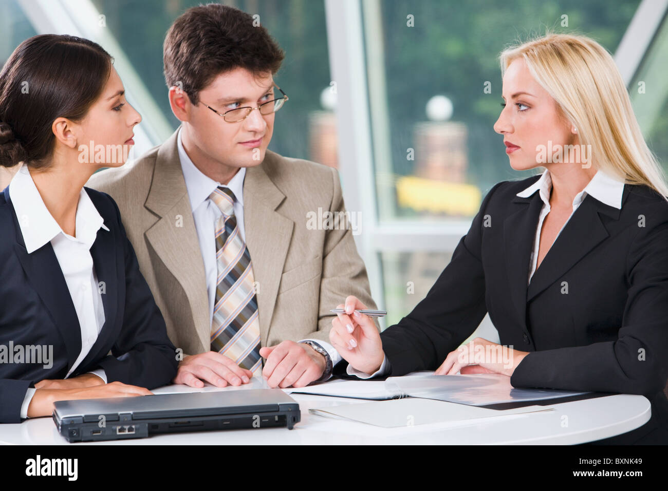 Three young professionals gathered together discussing important ...