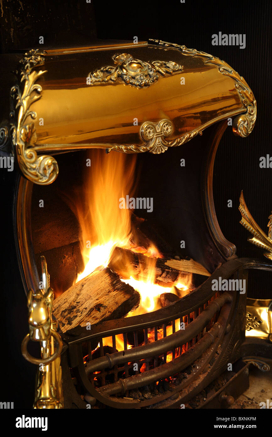 brass fireplace with real wood fire Stock Photo - Alamy