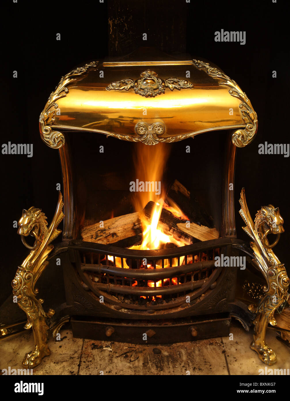 brass fireplace with real wood fire Stock Photo - Alamy