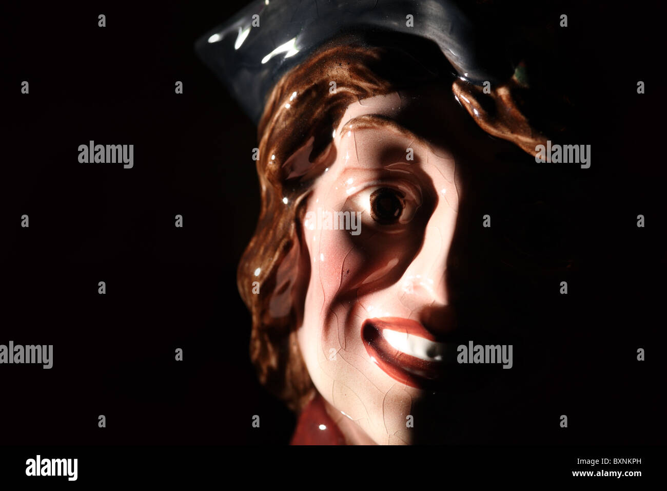 toby jug face in close up with directional light on black background ...