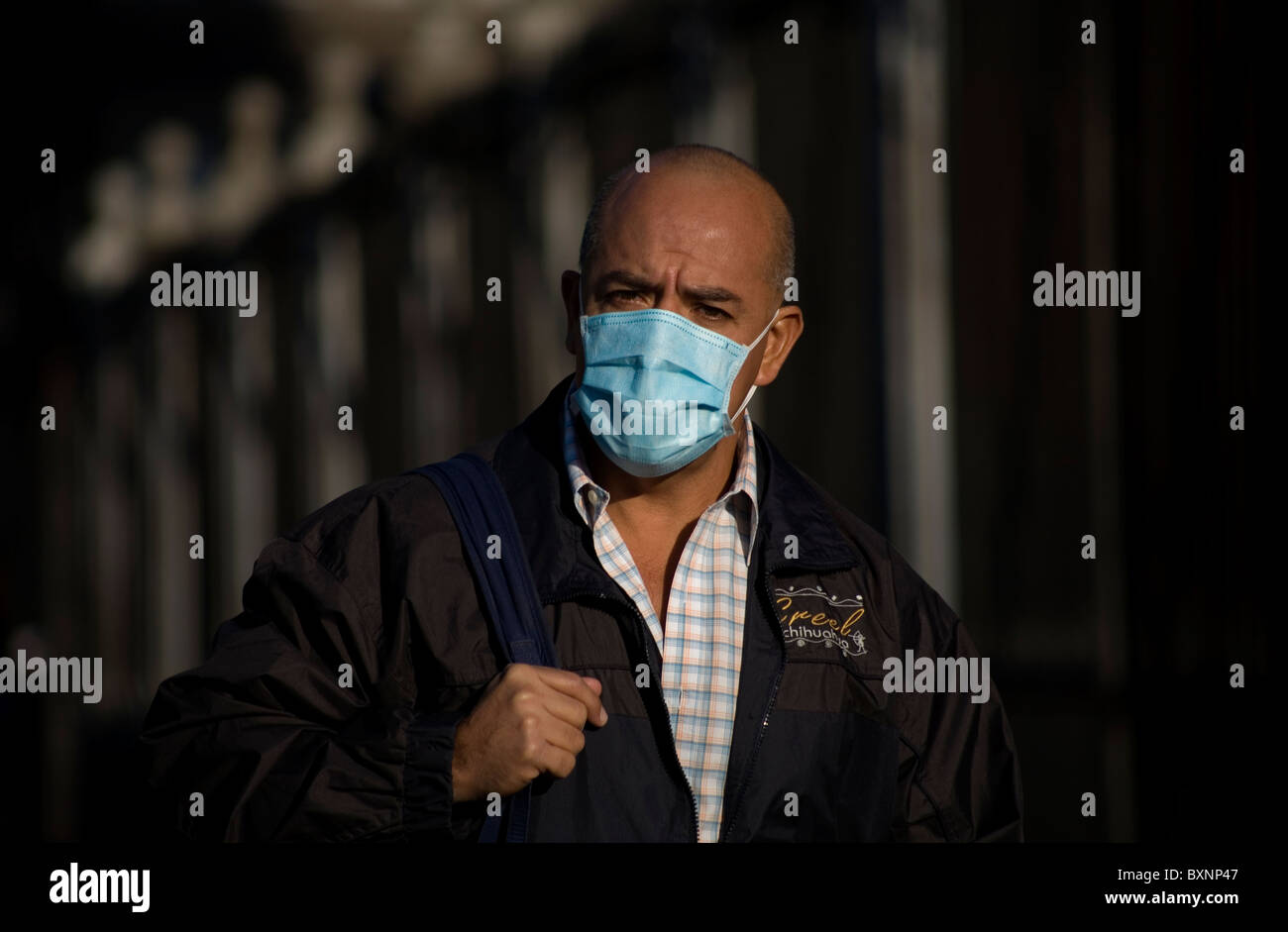 A man wearing a mask as a precaution against swine flu walks in Mexico ...