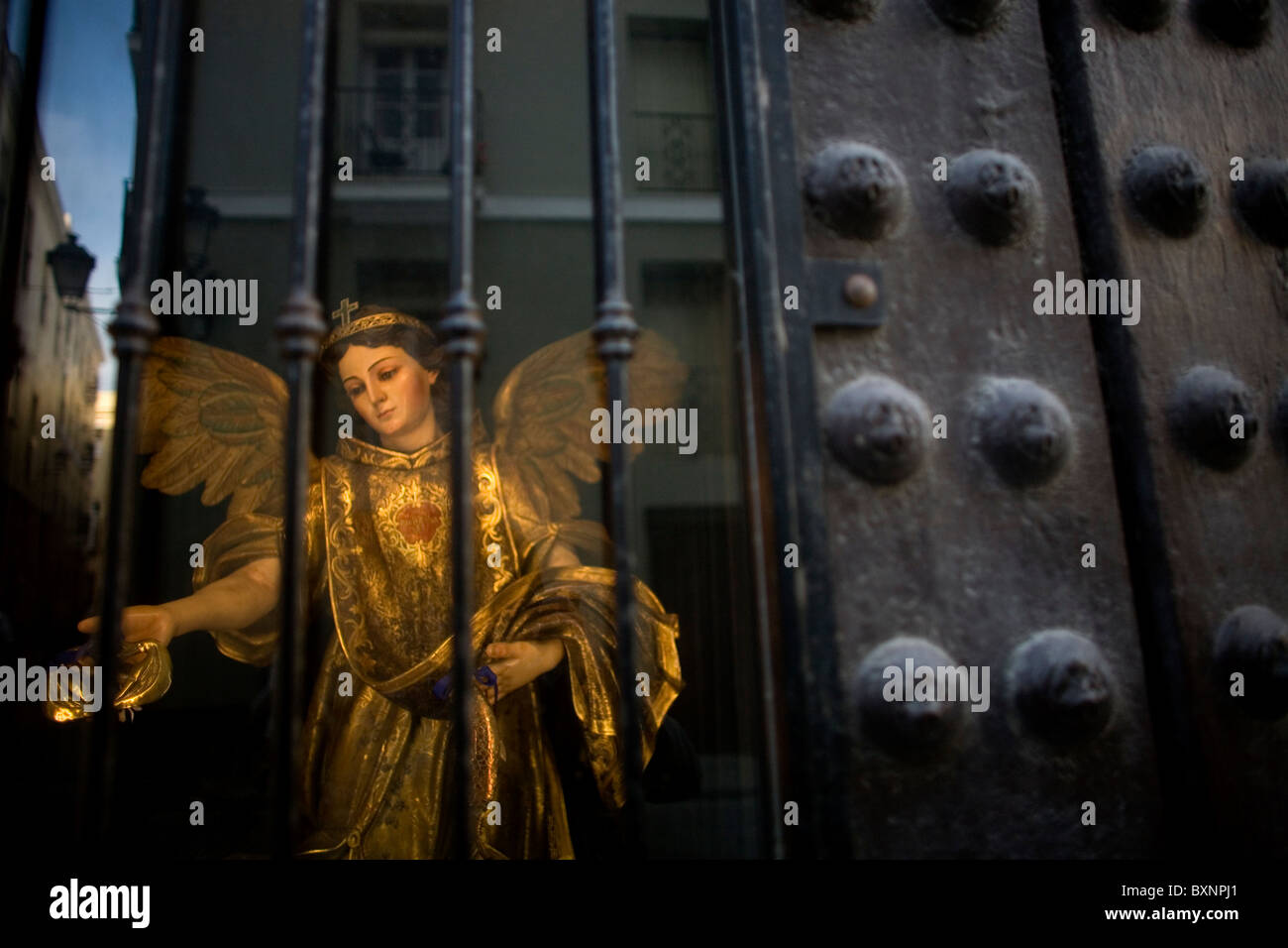 A statue of Saint Raphael Archangel sits behind a window as the city of ...