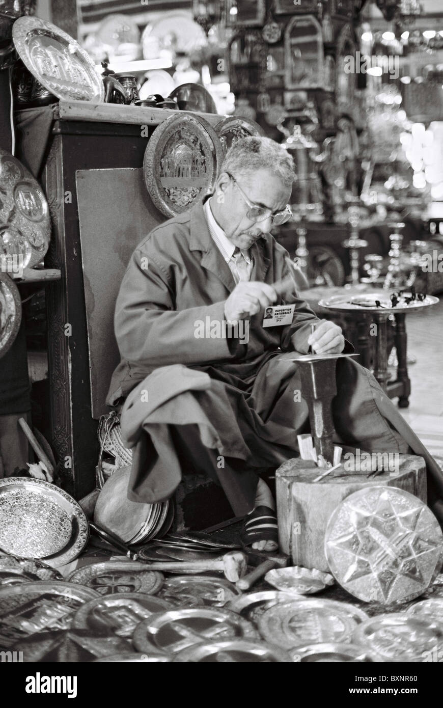 Man engraving traditional Moroccan patterns on copper & brass plates in ...