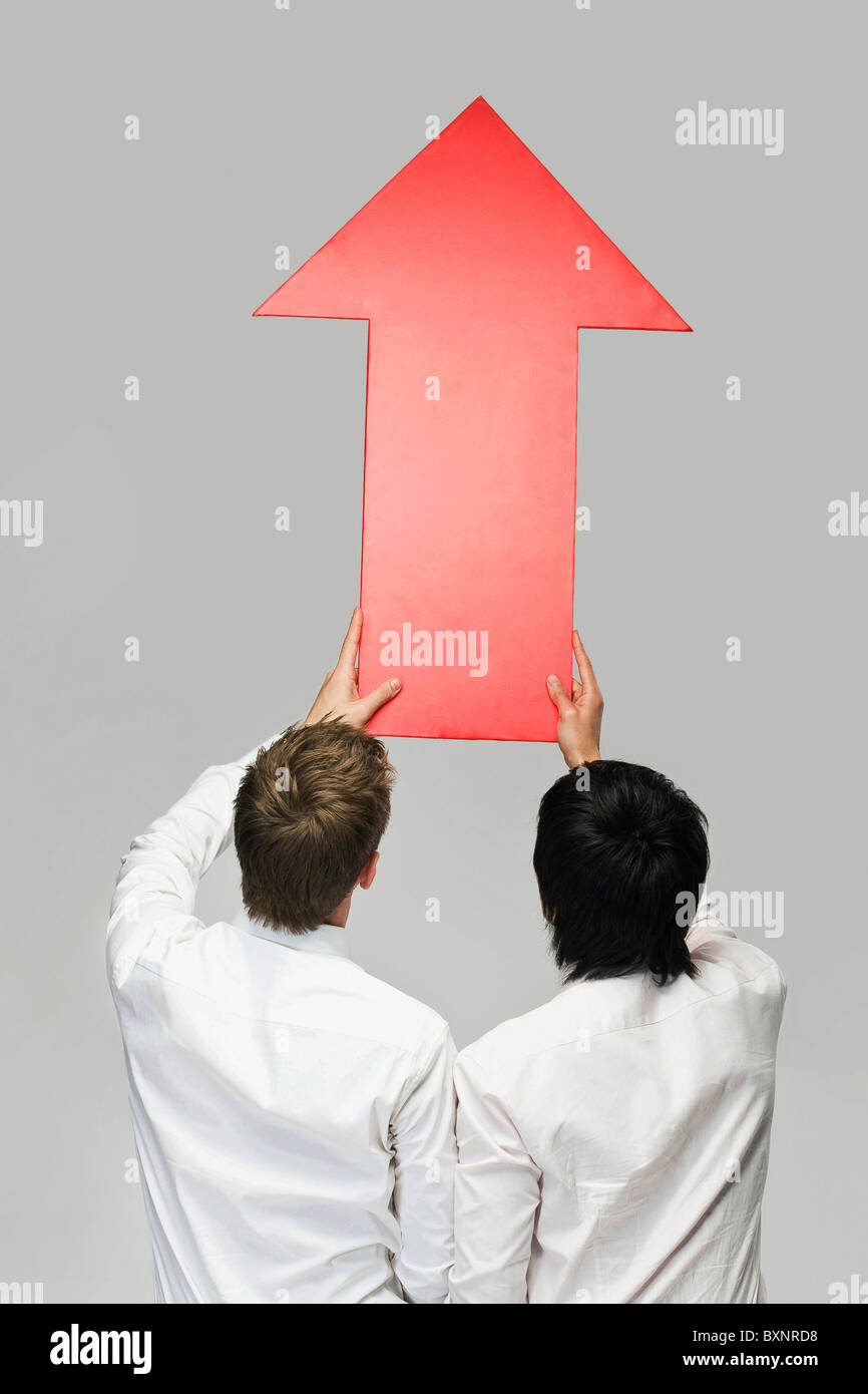 Two businessmen holding arrow together hi-res stock photography and ...