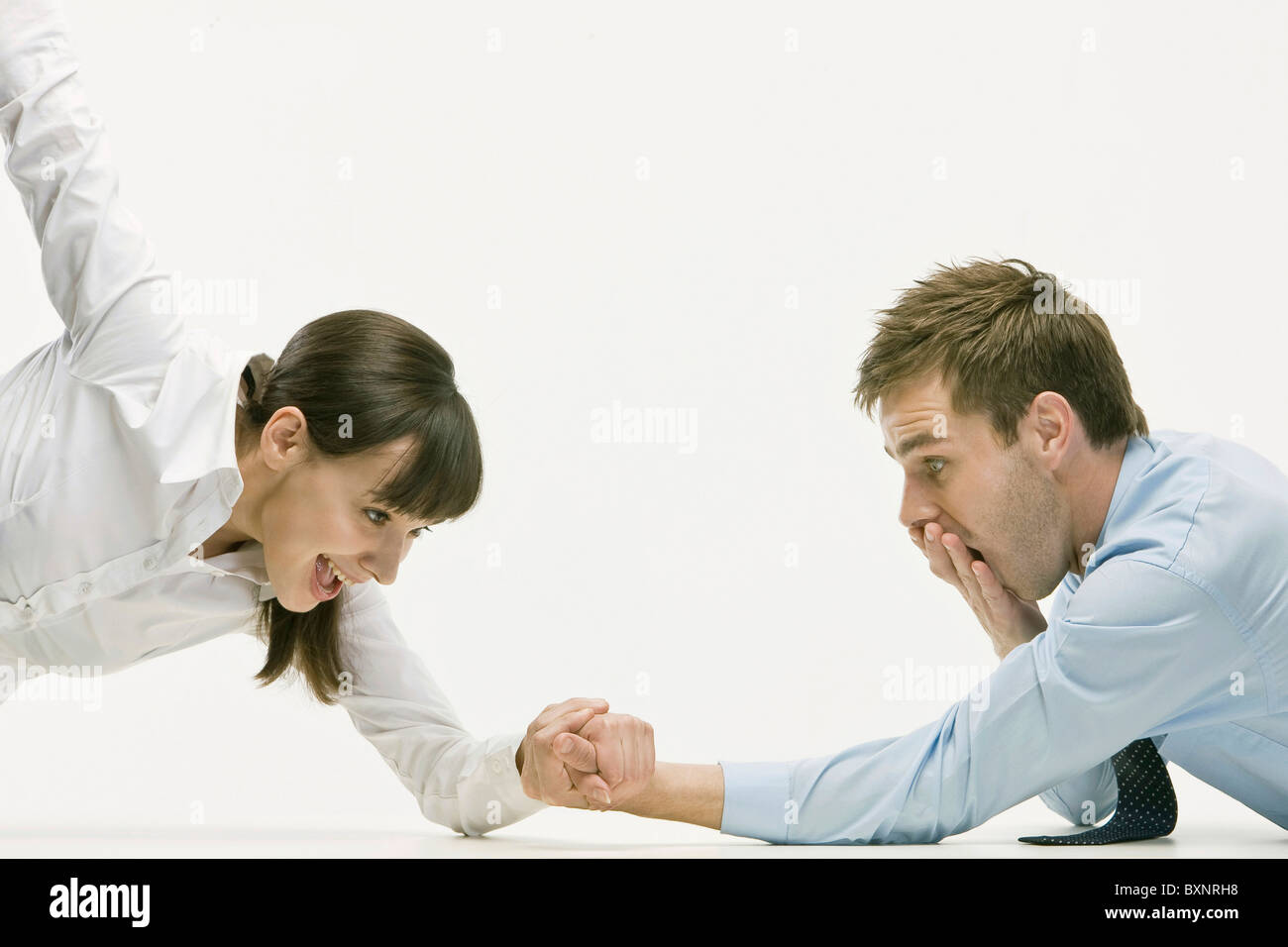 Businessman and woman arm wrestling over table Stock Photo - Alamy