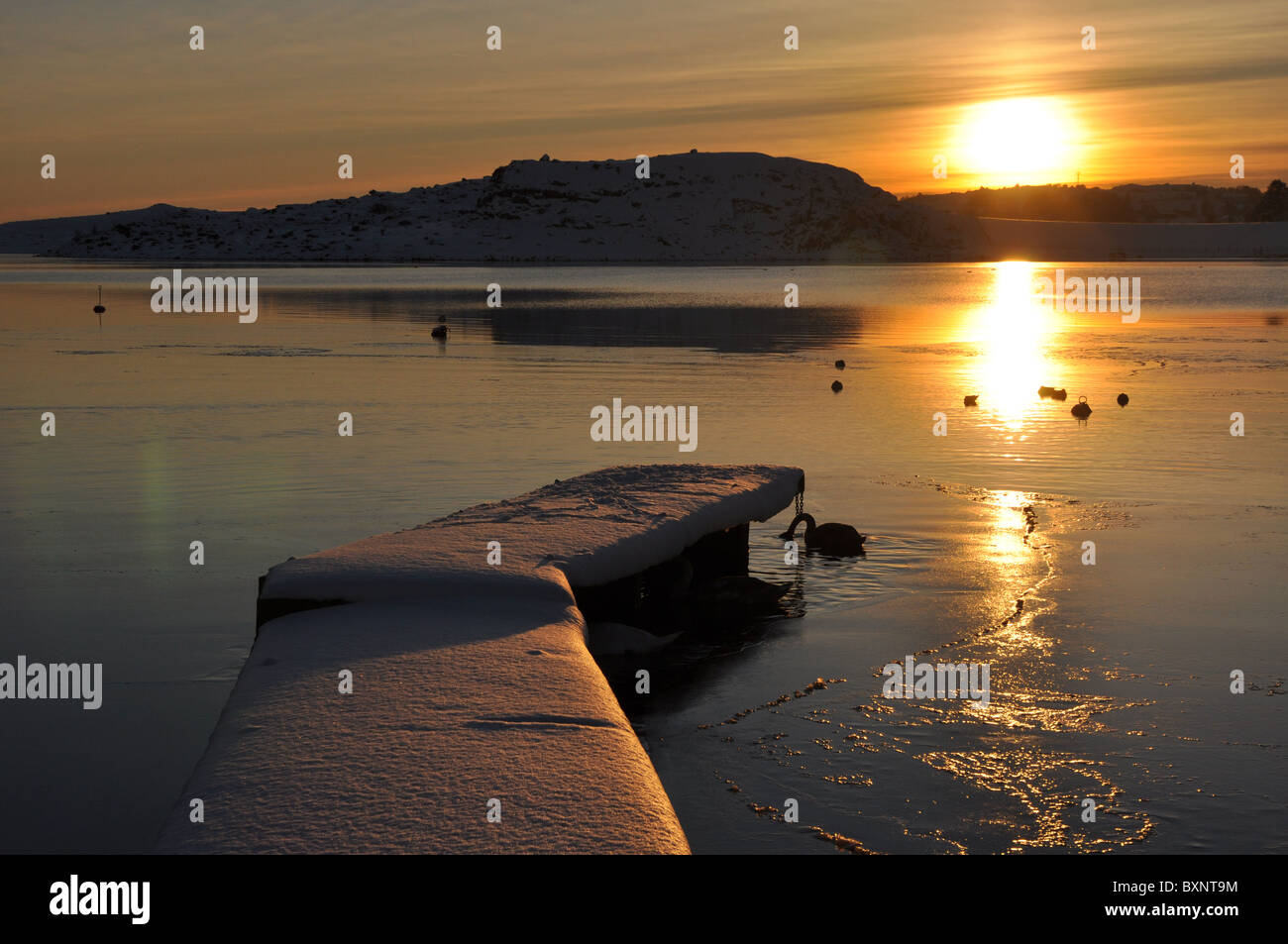 Winter by the sea at sunset, snow, ice on the sea, boat jetty Stock ...
