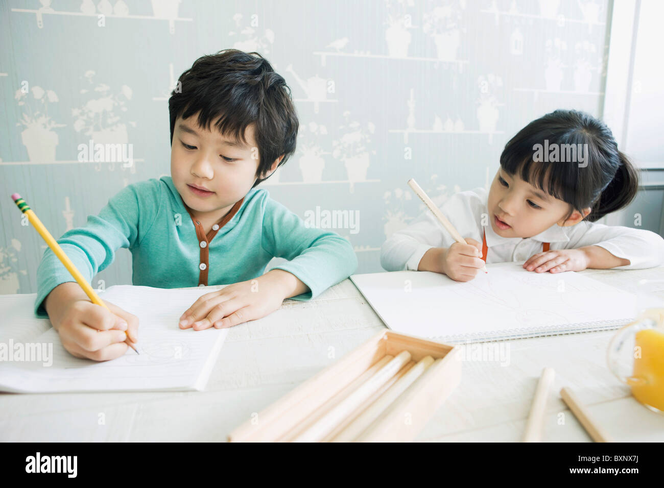 Boy and girl doing homework at table Stock Photo - Alamy