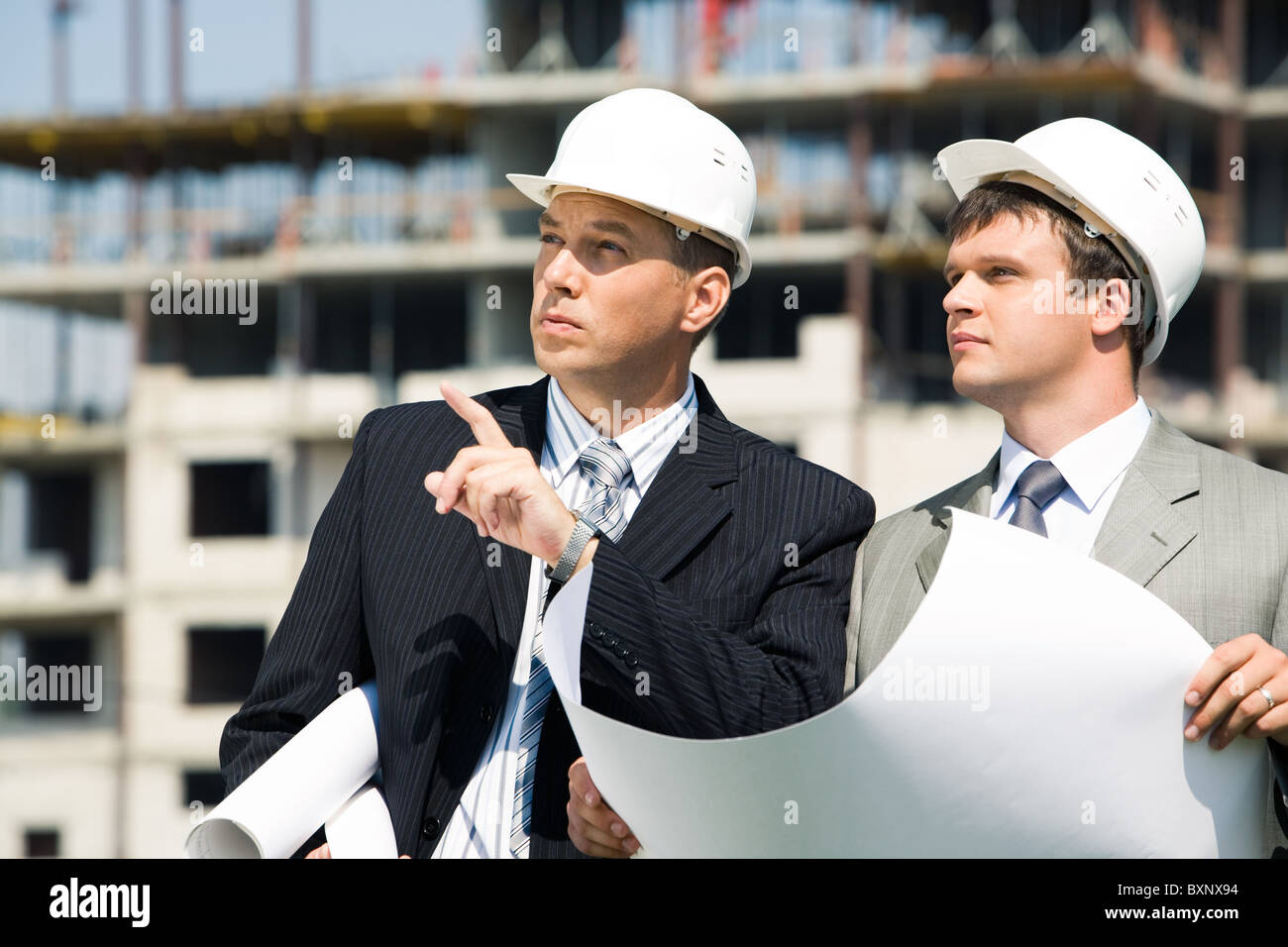 Portrait of successful boss explaining and pointing to a place to ...