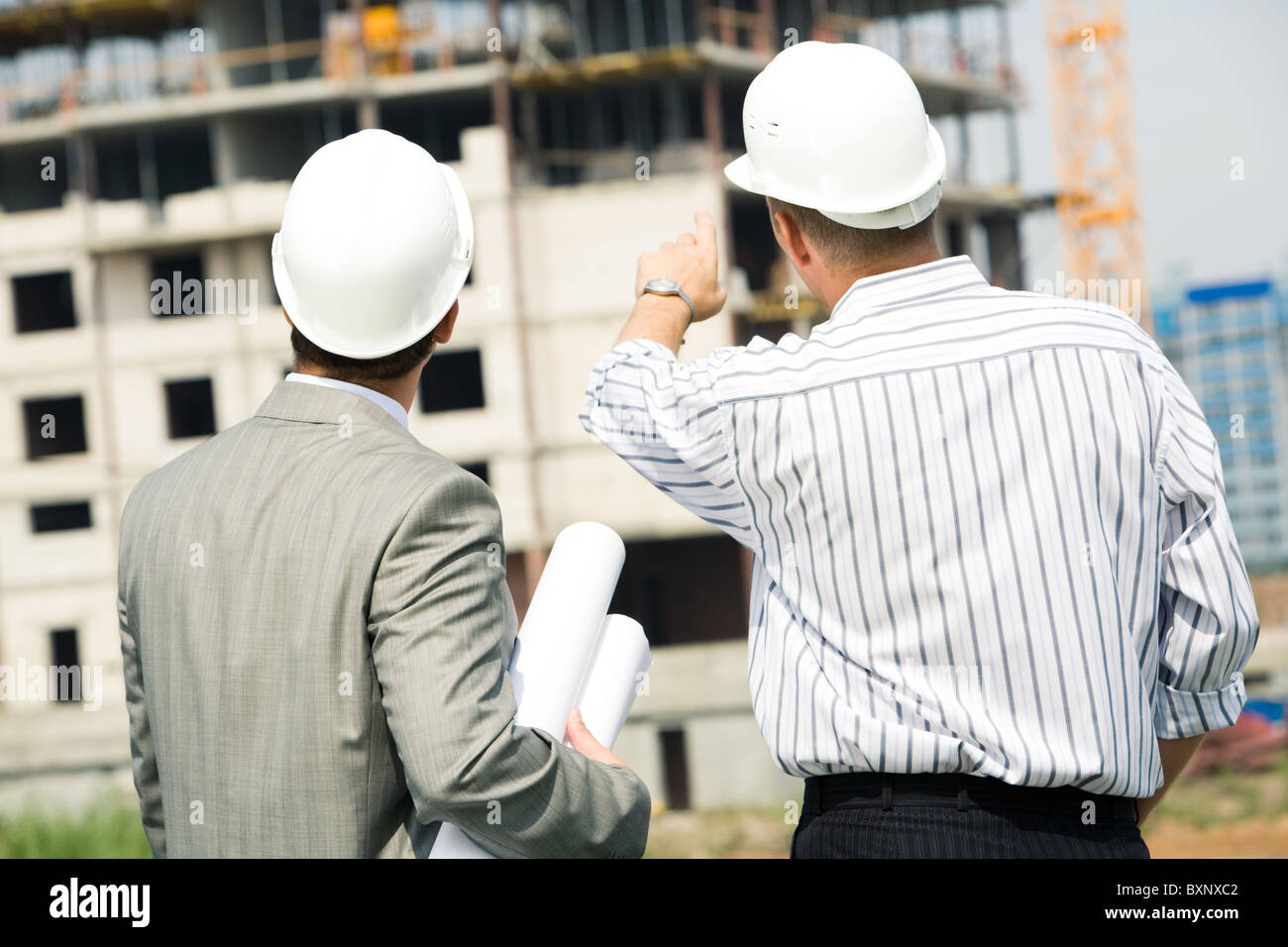 Portrait of boss pointing at construction with worker near by Stock ...