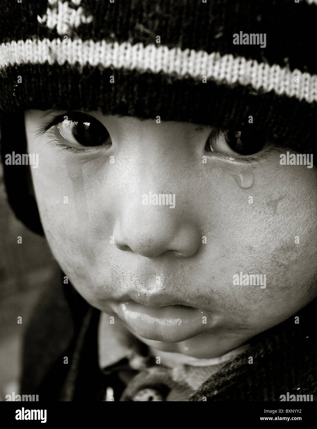 China October 2008. Scared or sad, a little boy in the back streets of ...