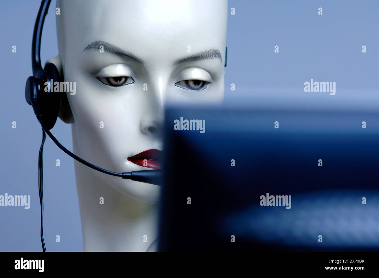 Mannequin behind a computer screen wearing a call centre telephone head ...