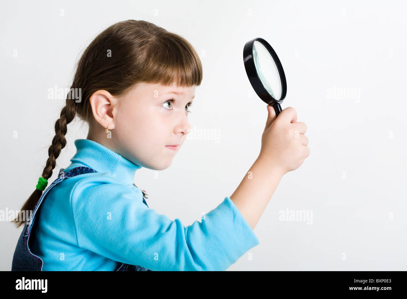 Image of cute girl with lens in hand looking slightly upwards through ...