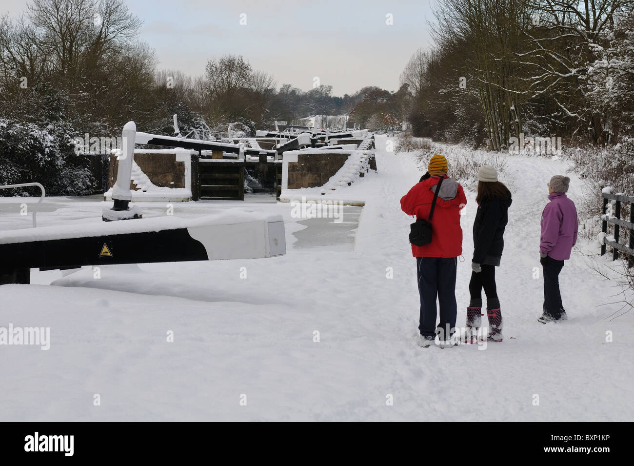 People standing by Grand Union Canal at Hatton Locks with snow ...