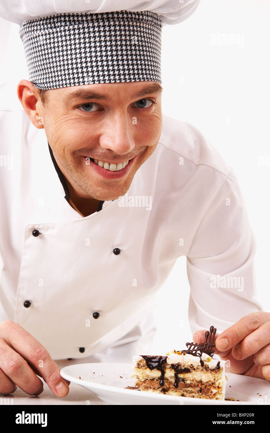 Portrait of handsome man in cook uniform looking at camera with tasty ...