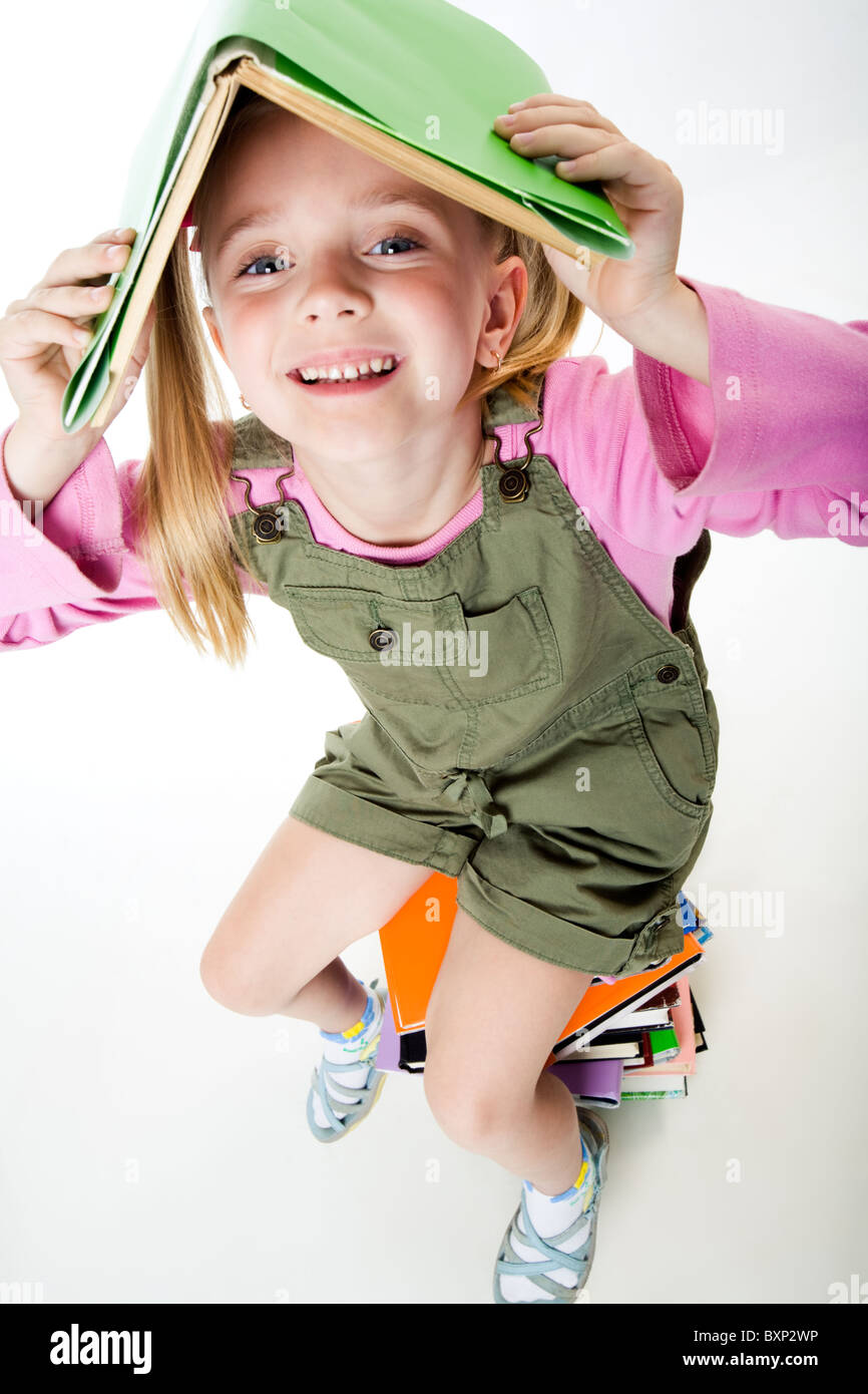 Image of pretty young girl under book in the studio Stock Photo - Alamy