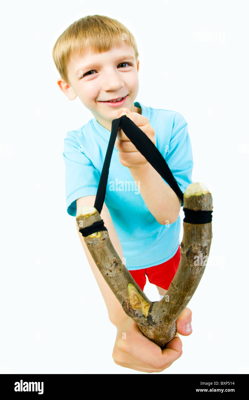 Portrait of playful boy with slingshot ready to catapult over white ...