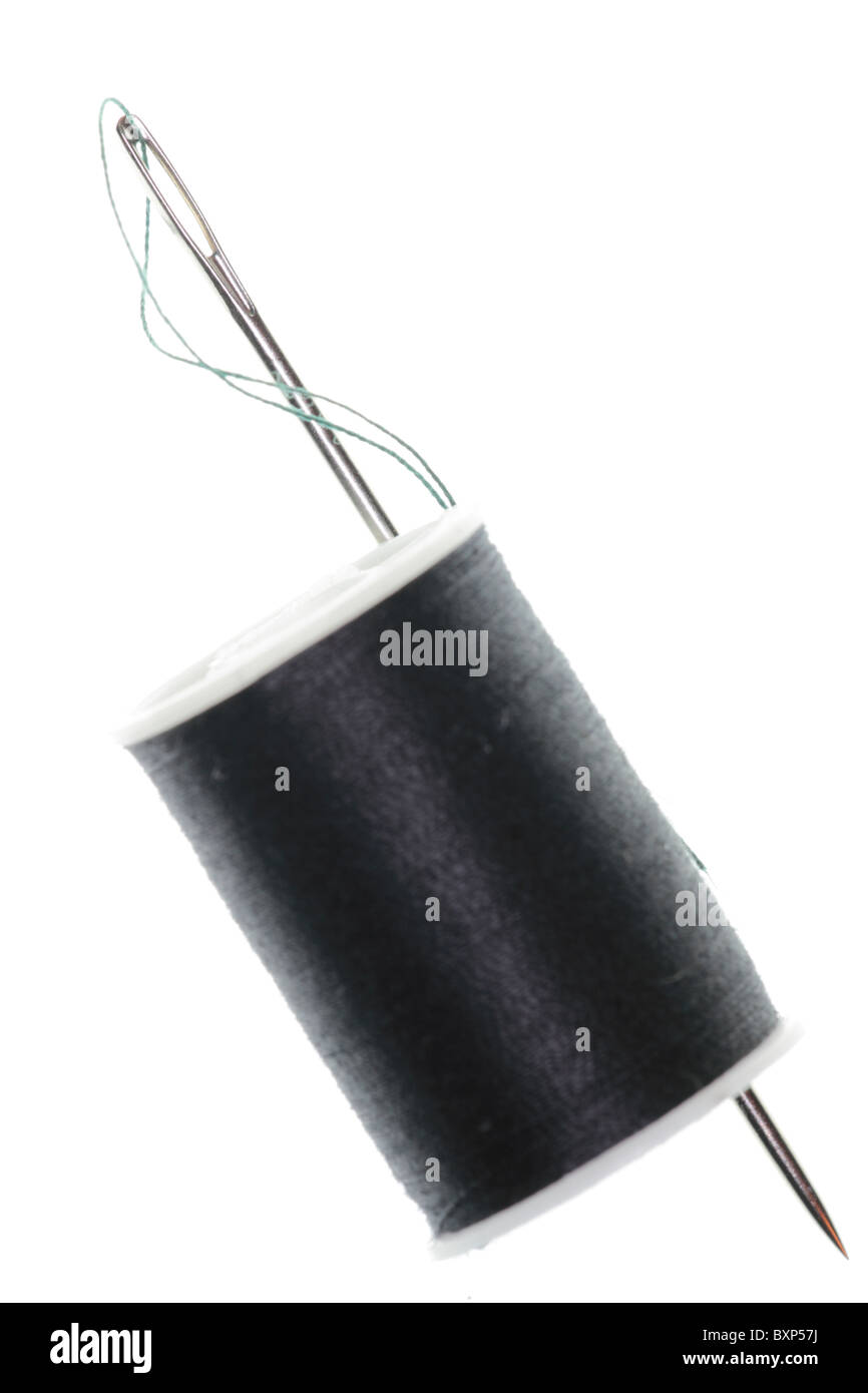 Black cotton Reel with threaded needle Stock Photo - Alamy