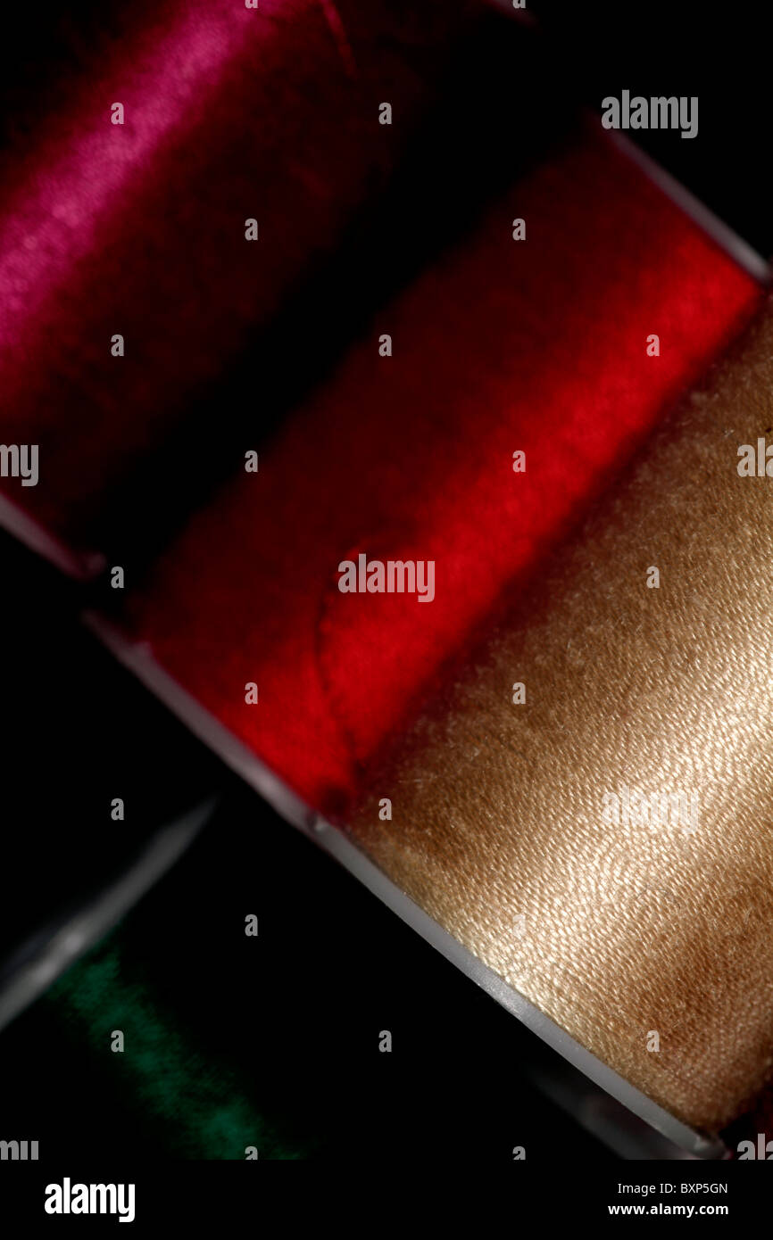 red and gold coloured cotton reels in macro Stock Photo - Alamy