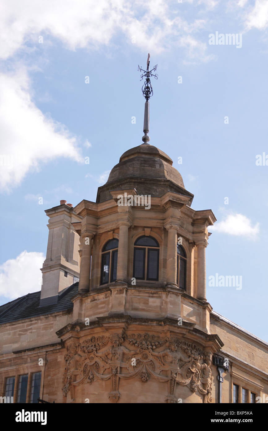 Weather vane on a stone spire tower with old English leaded windows ...