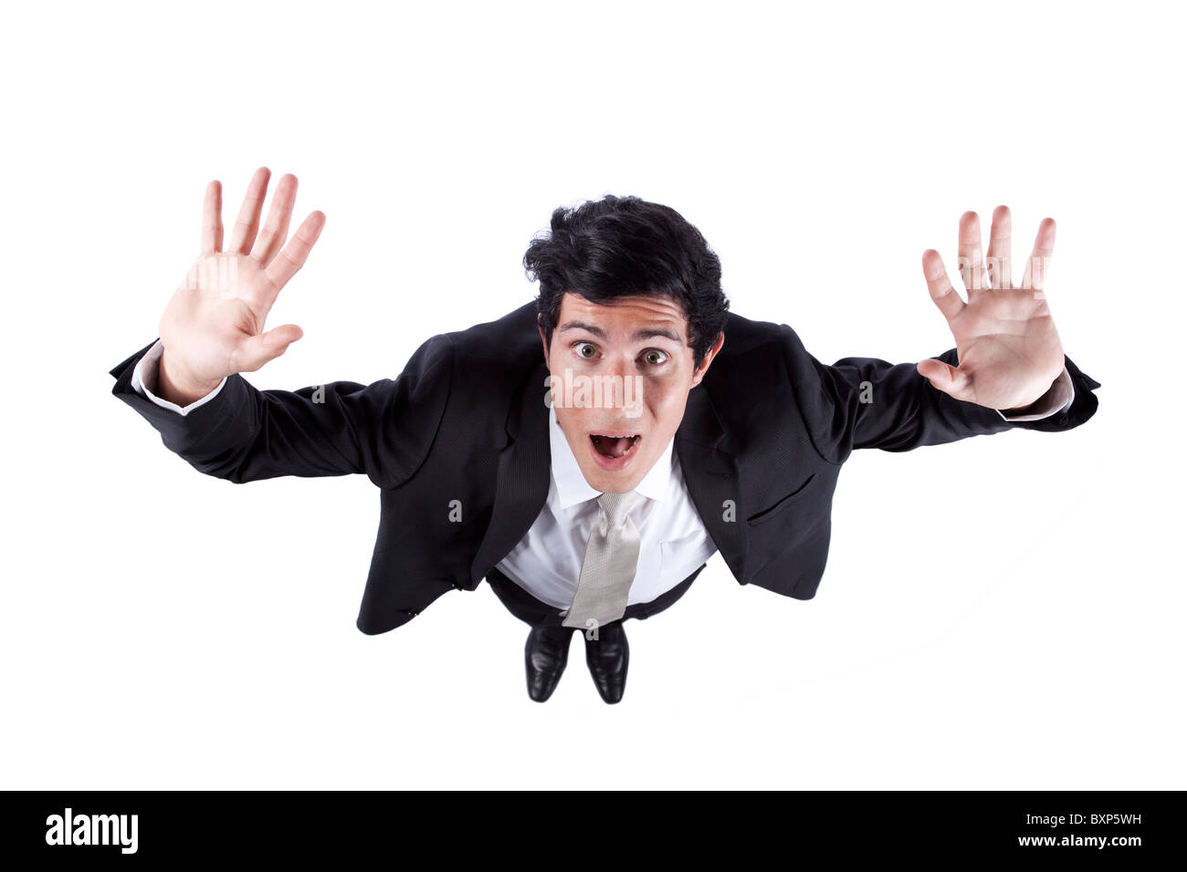 Young businessman screaming and scared with his arms up (above view ...