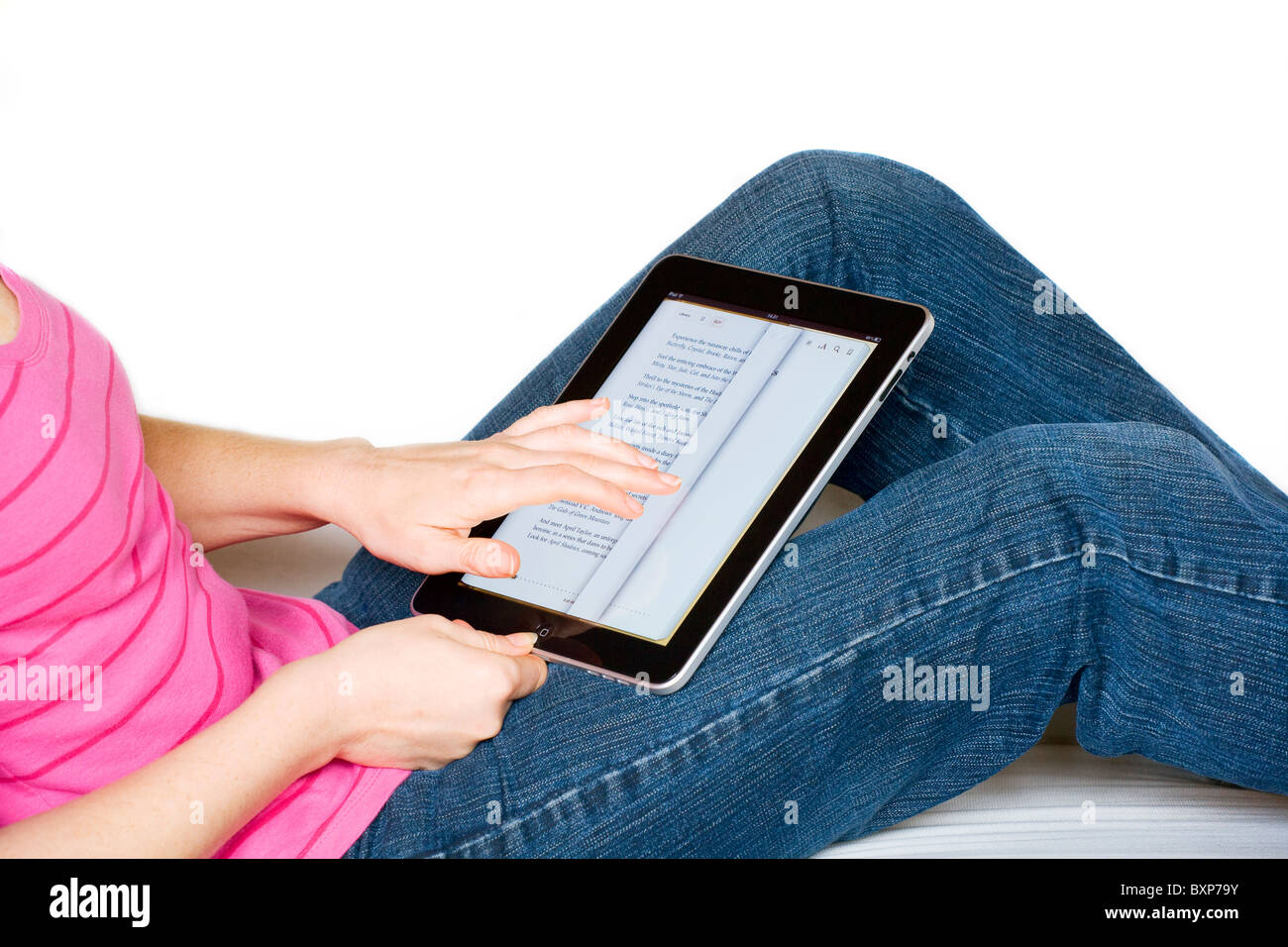 Woman relaxing using an Apple Mac iPad reading a book with iBooks and ...
