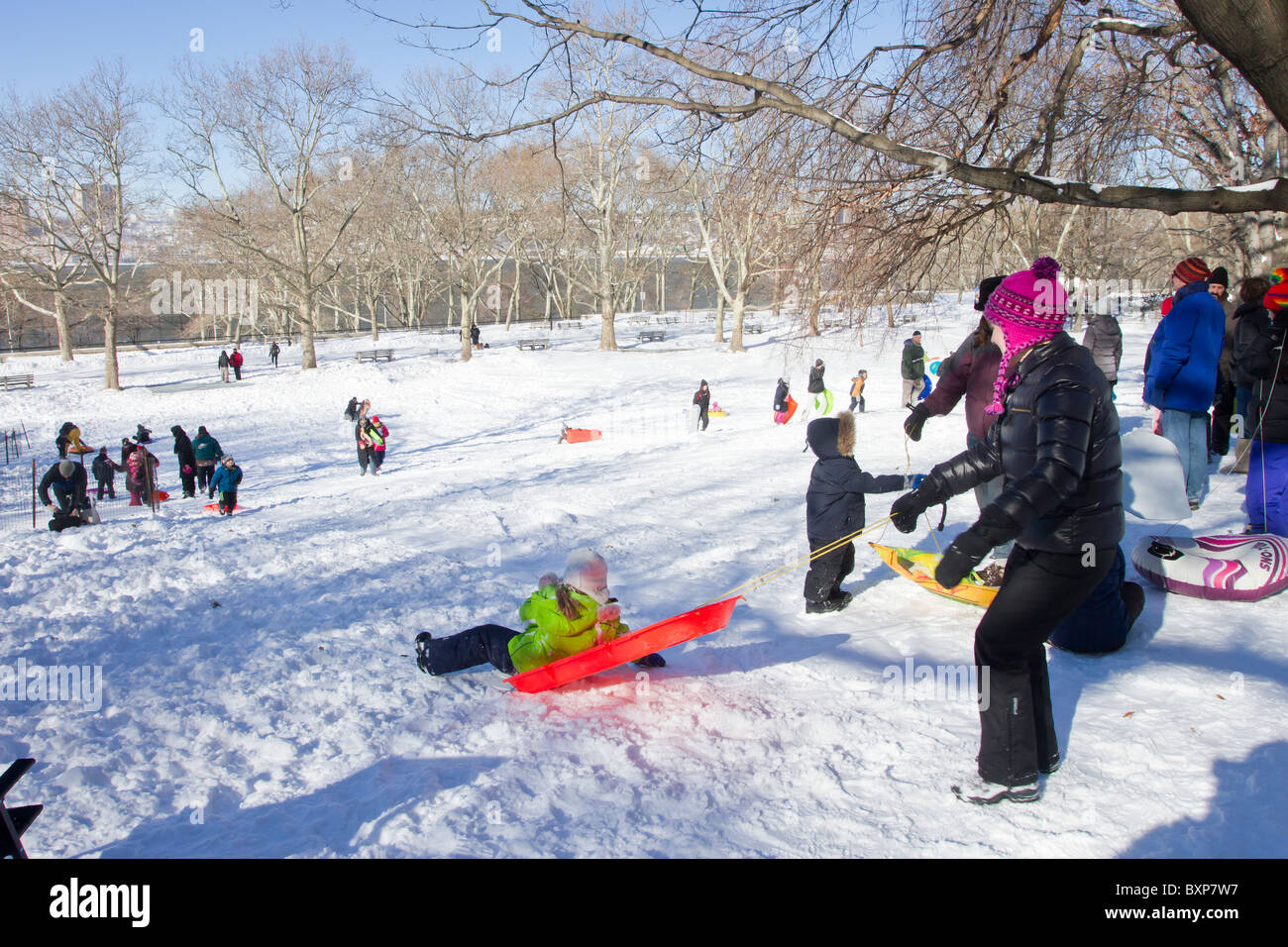 Adults and children at the top of a sled run in Riverside Park on the ...