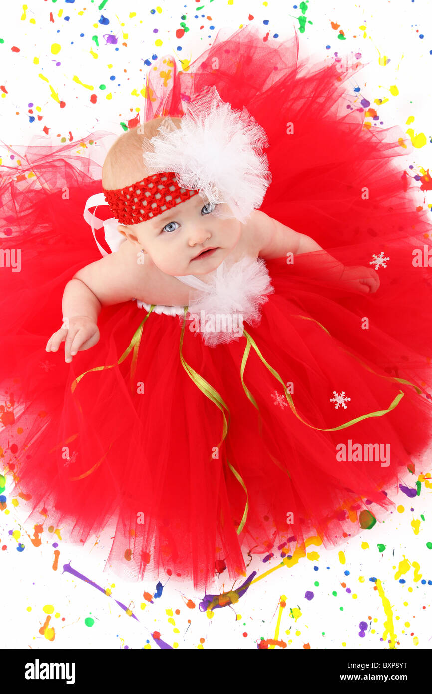 Adorable 4 month old baby girl sitting on paint splattered floor ...