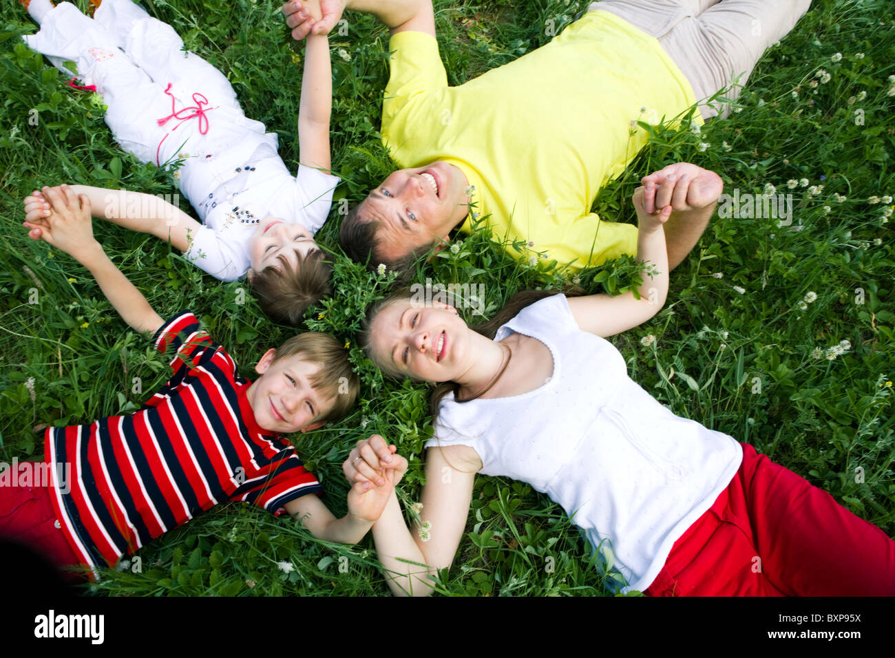 View from above of relaxing people lying on grass of meadow during rest ...